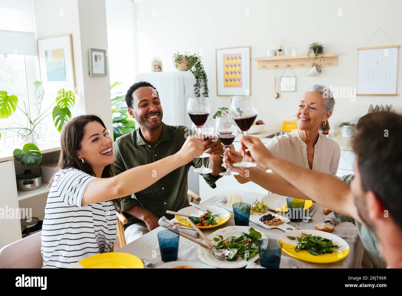 Family raising toast on dining table in kitchen Stock Photo - Alamy