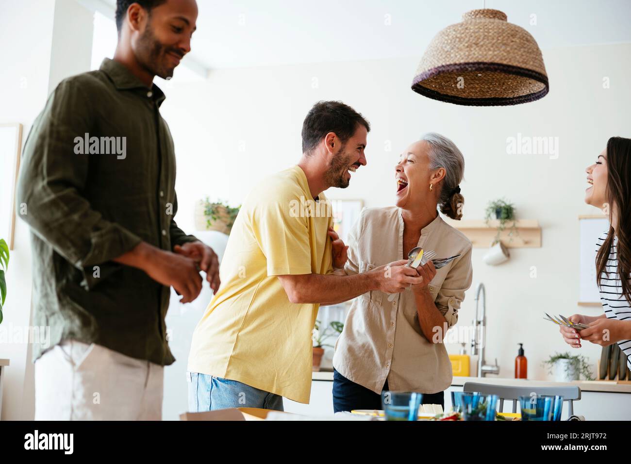 Happy family greeting next to dining table in kitchen Stock Photo - Alamy