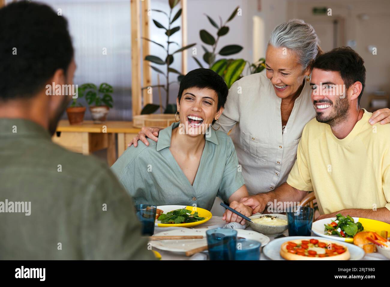 Happy family having lunch together at dining table in kitchen Stock ...
