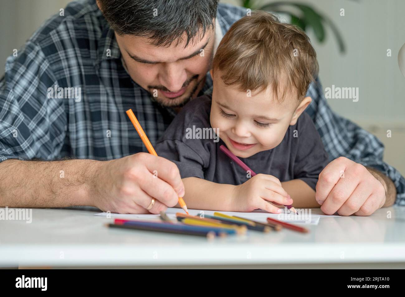Father and son coloring together at home Stock Photo - Alamy