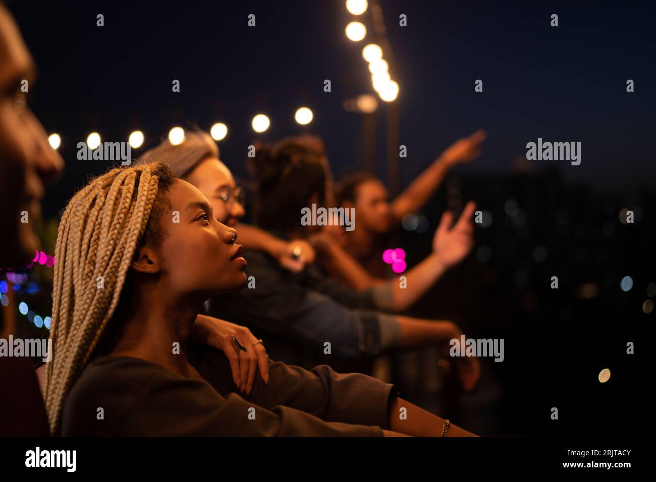 Friends having social gathering on rooftop at night Stock Photo - Alamy