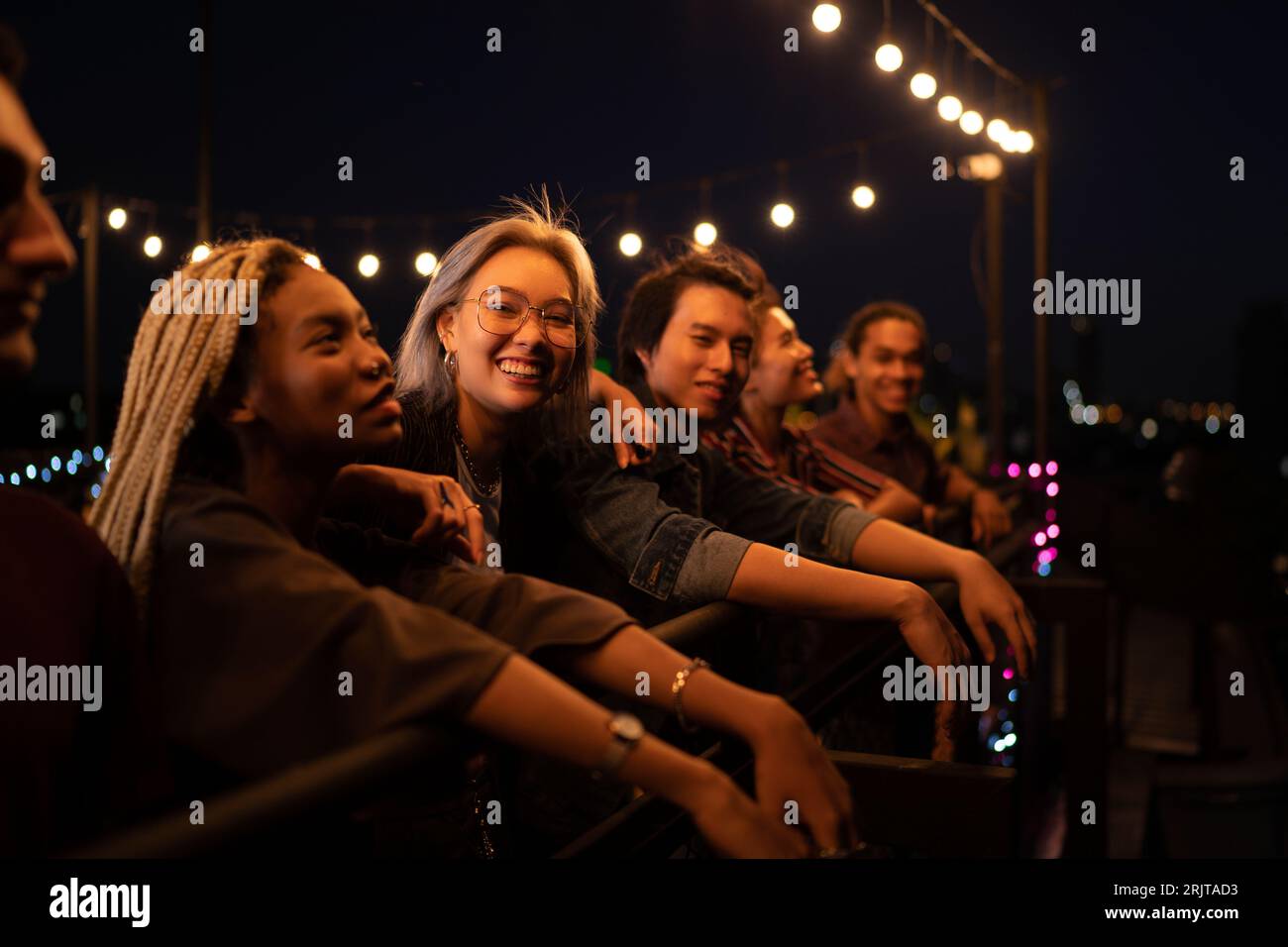 Happy friends having social gathering on rooftop at night Stock Photo ...