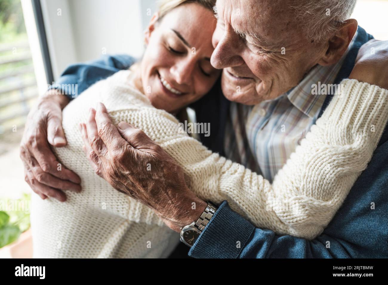 Smiling woman hugging father at home Stock Photo - Alamy