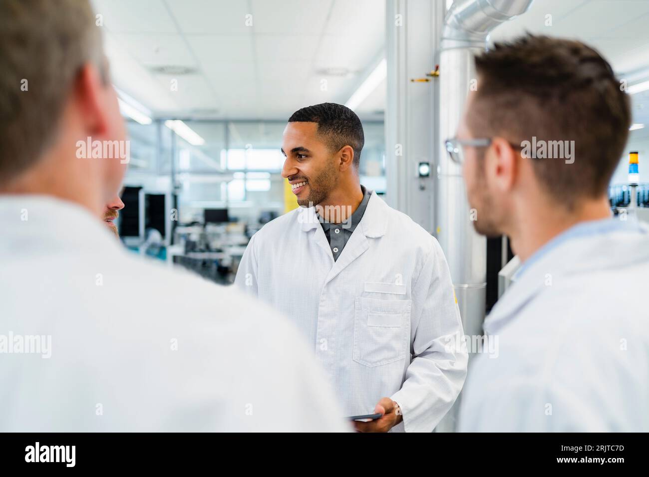 Team of competent electrical technicians in lab coats having meeting in ...
