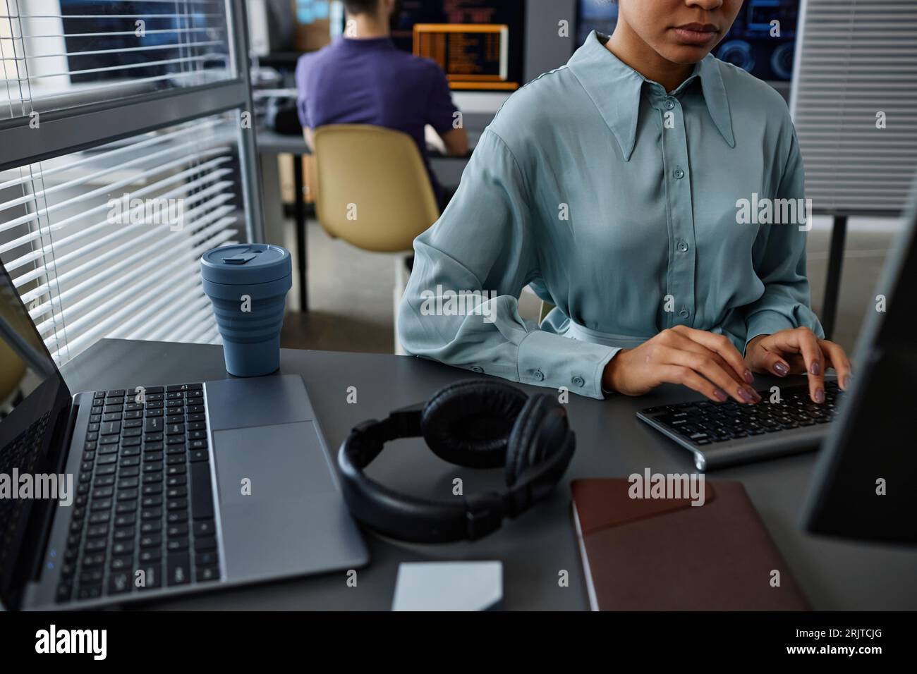 IT professional typing on keyboard with colleague in background Stock ...