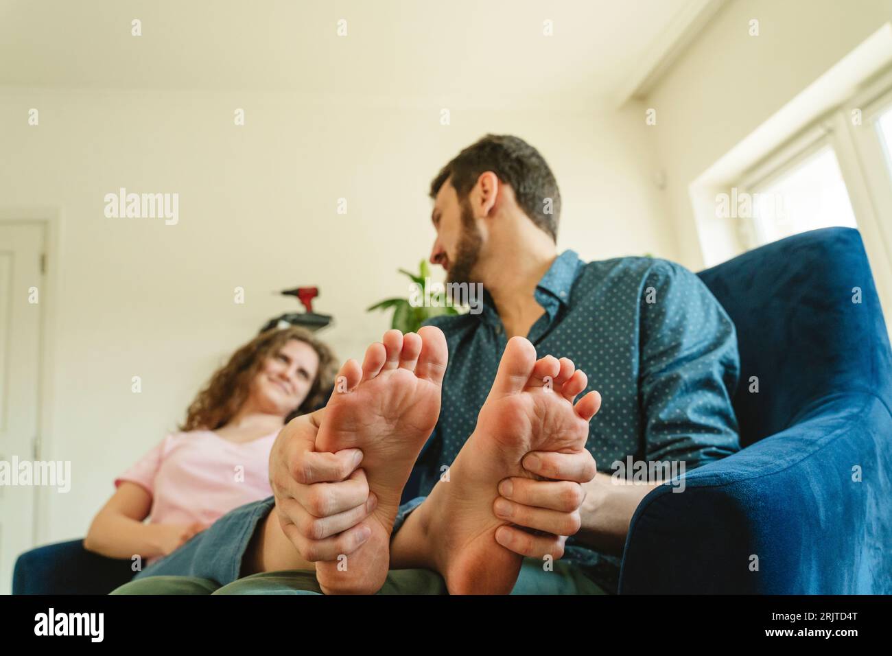 Man massaging feet of girlfriend after moving into new house Stock ...