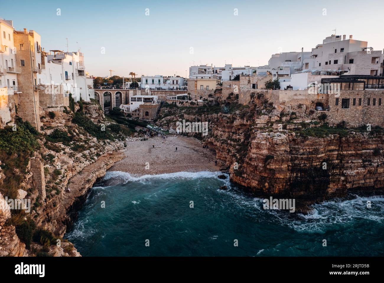 A picturesque landscape of a coastal cliff face and buildings Polignano ...