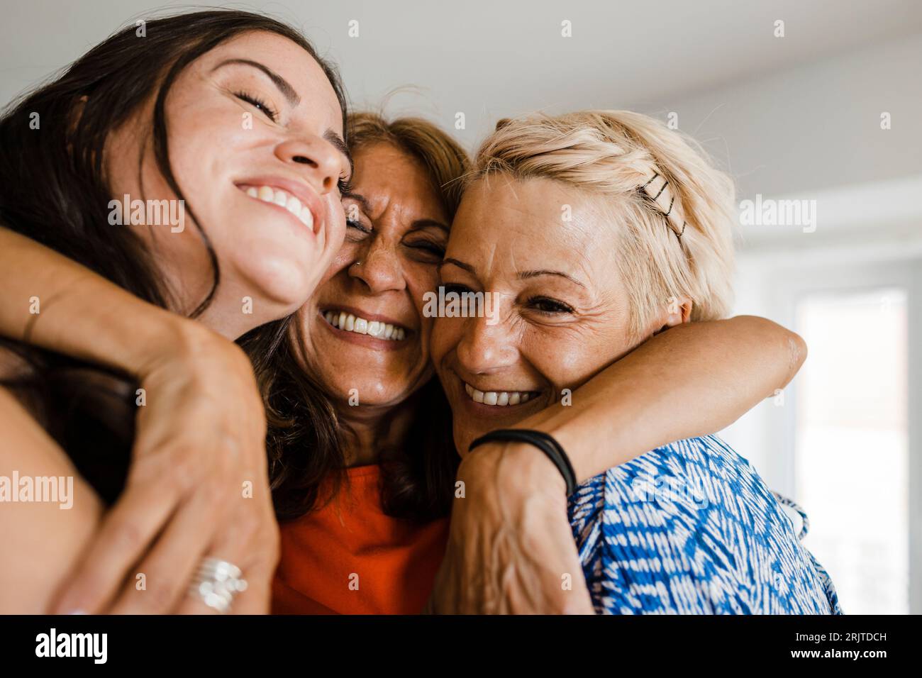Three friends hugging indoors hi-res stock photography and images - Alamy
