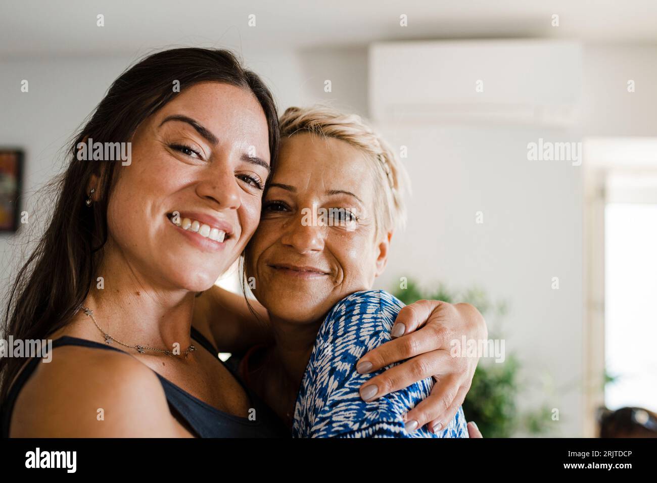Happy friends hugging each other in apartment Stock Photo - Alamy