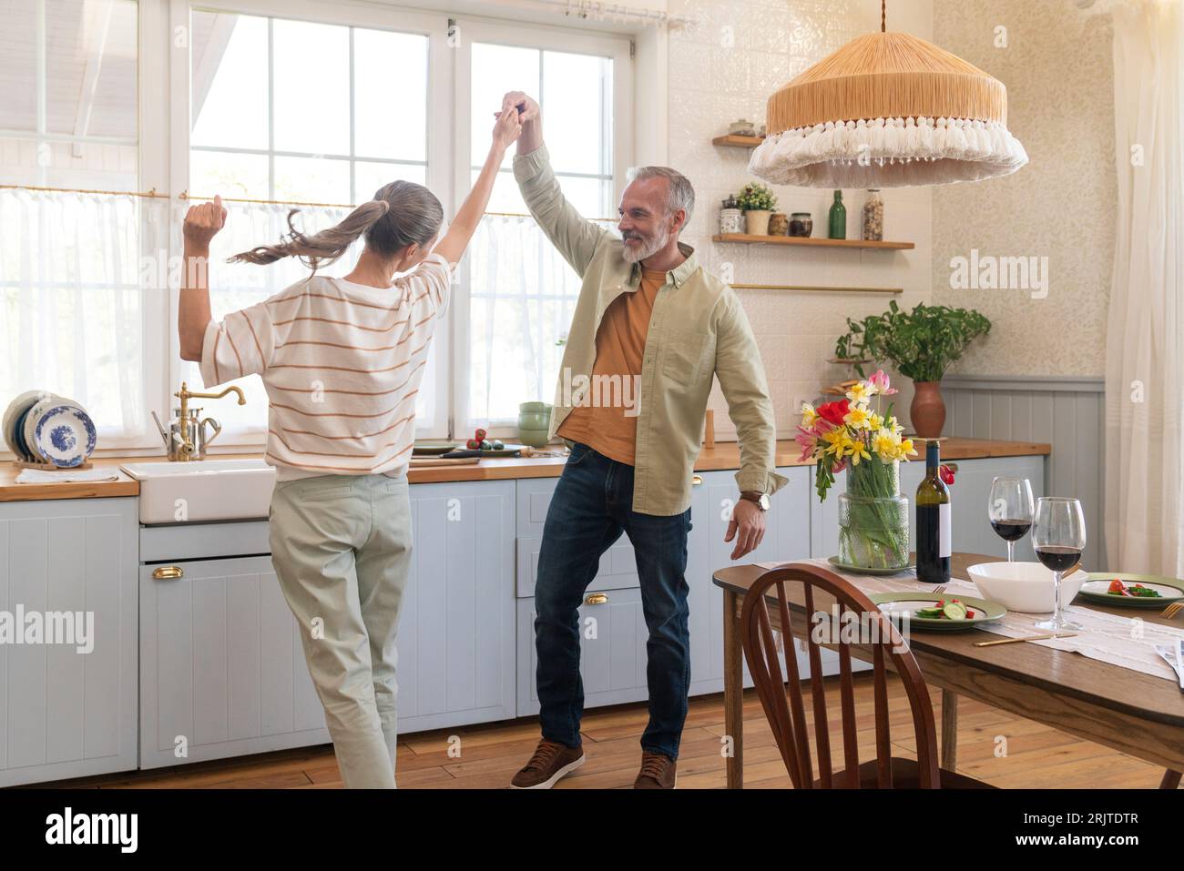Happy mature couple dancing in kitchen at home Stock Photo - Alamy