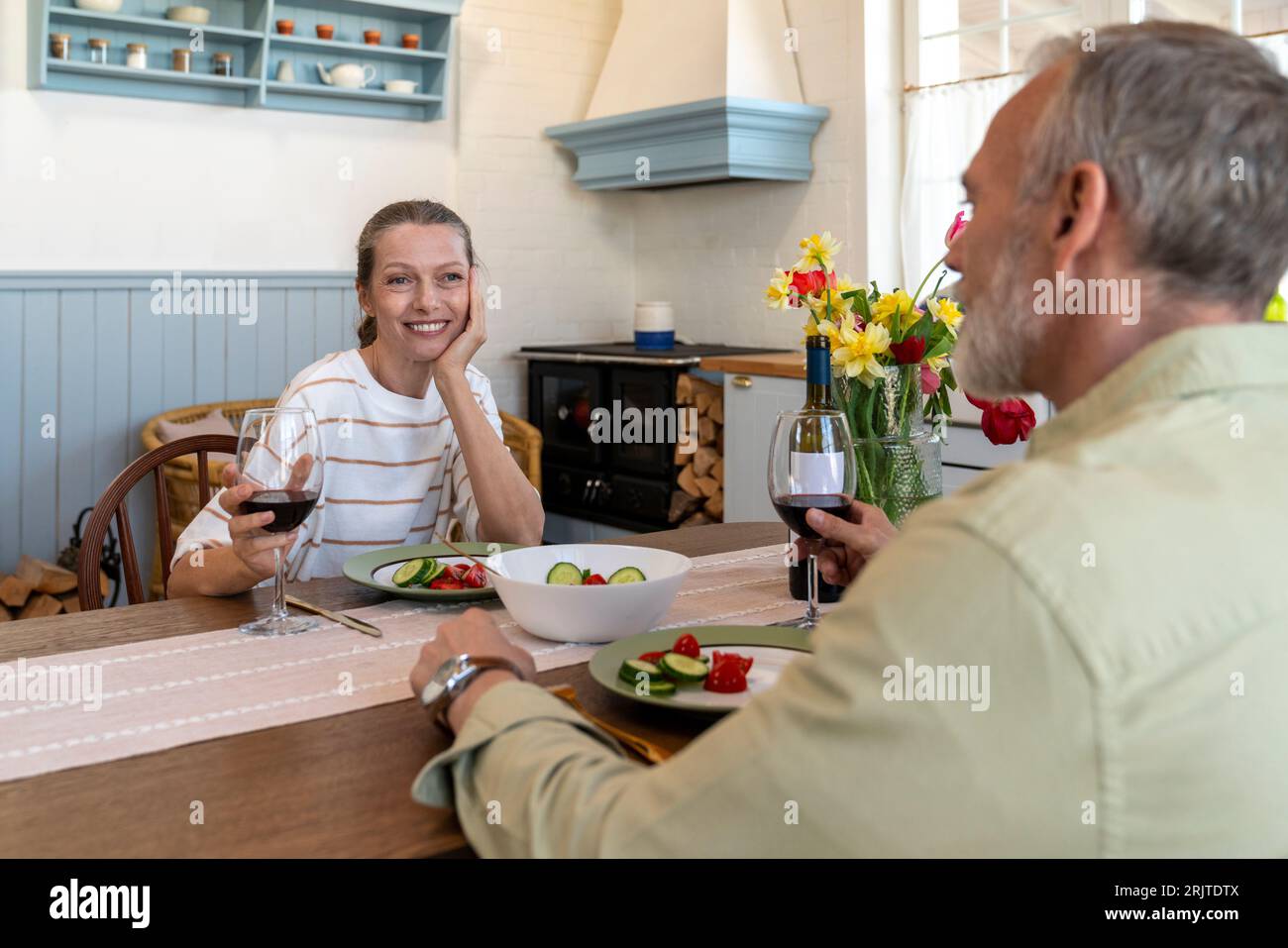 Mature couple having dinner sitting at dining table at home Stock Photo ...