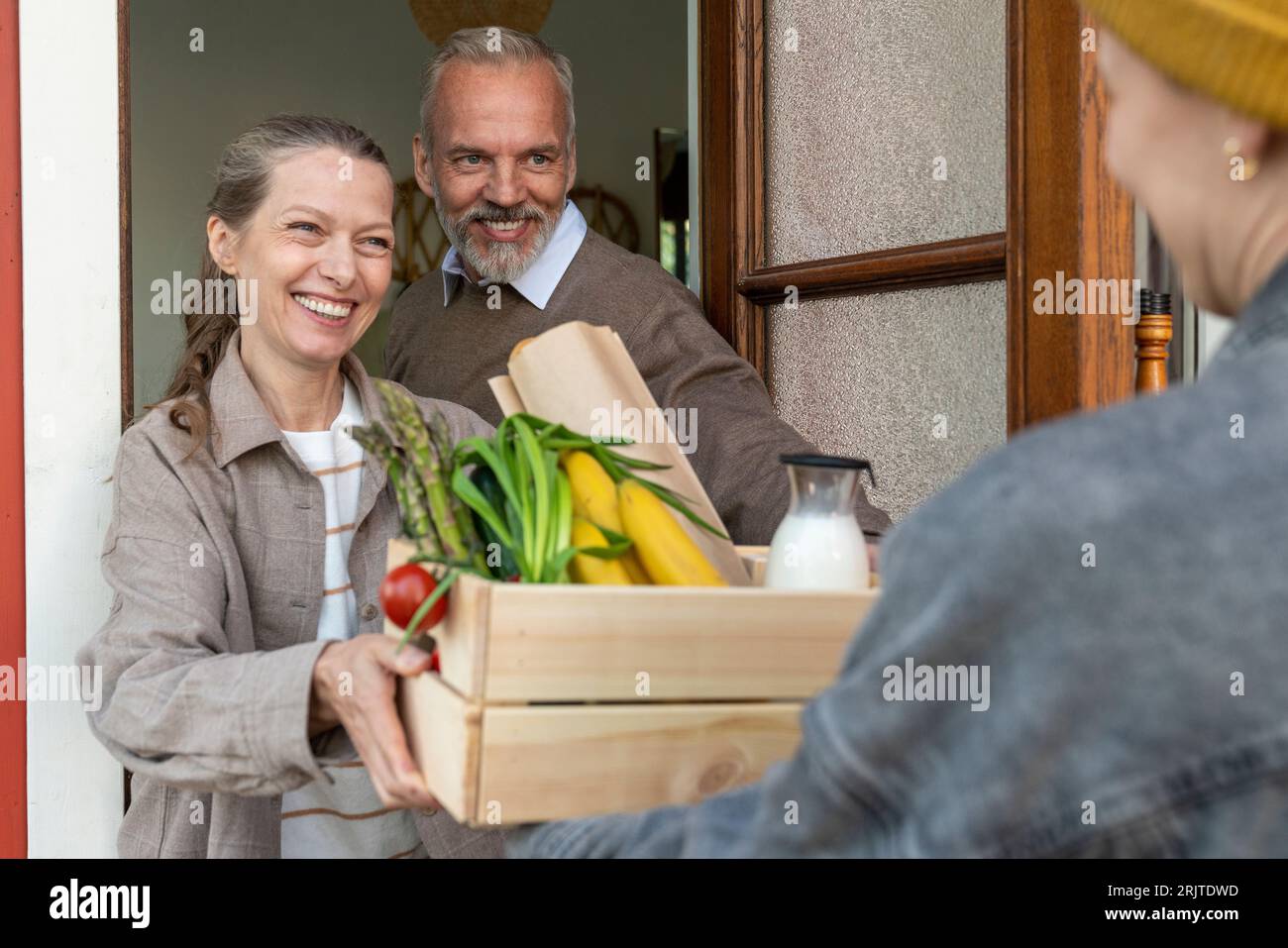 Happy mature couple receiving groceries via home delivery Stock Photo ...