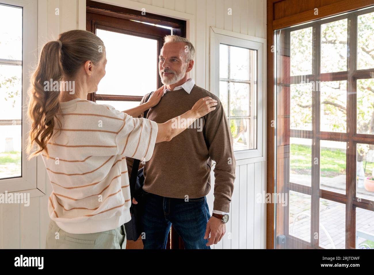 Woman saying goodbye to man leaving for work Stock Photo - Alamy