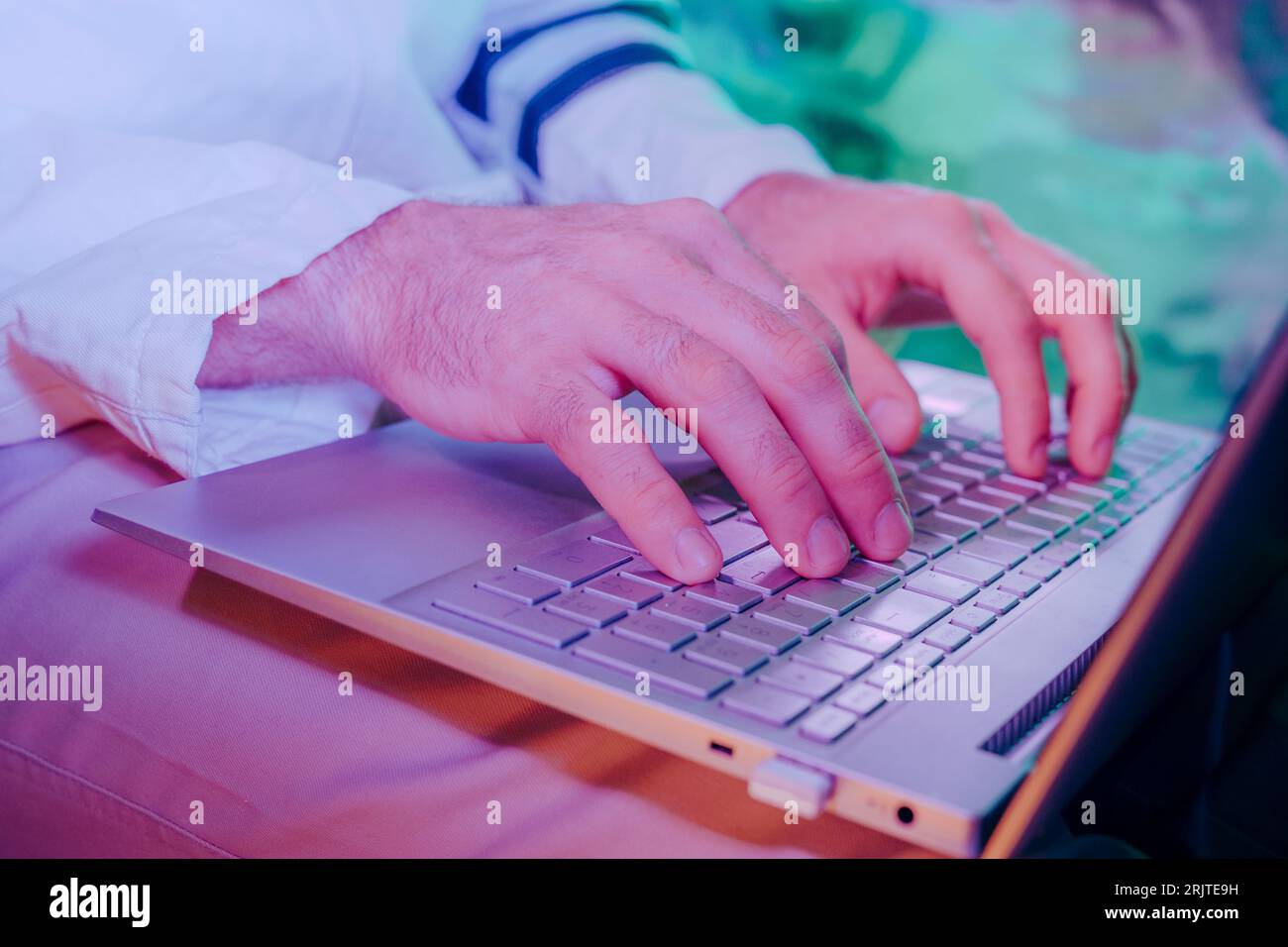 Hand in neon light typing hi-res stock photography and images - Alamy