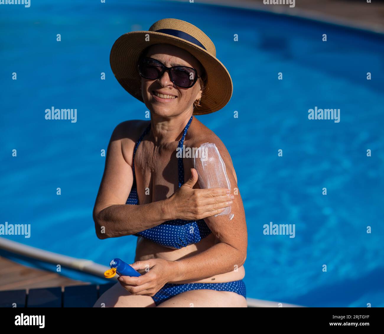 Woman applying sunscreen pool enjoying hi-res stock photography and ...