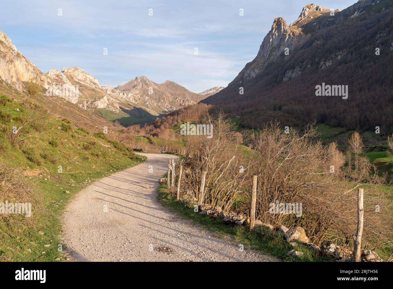 A scenic view of a winding road at the base of a beautiful, mountainous ...