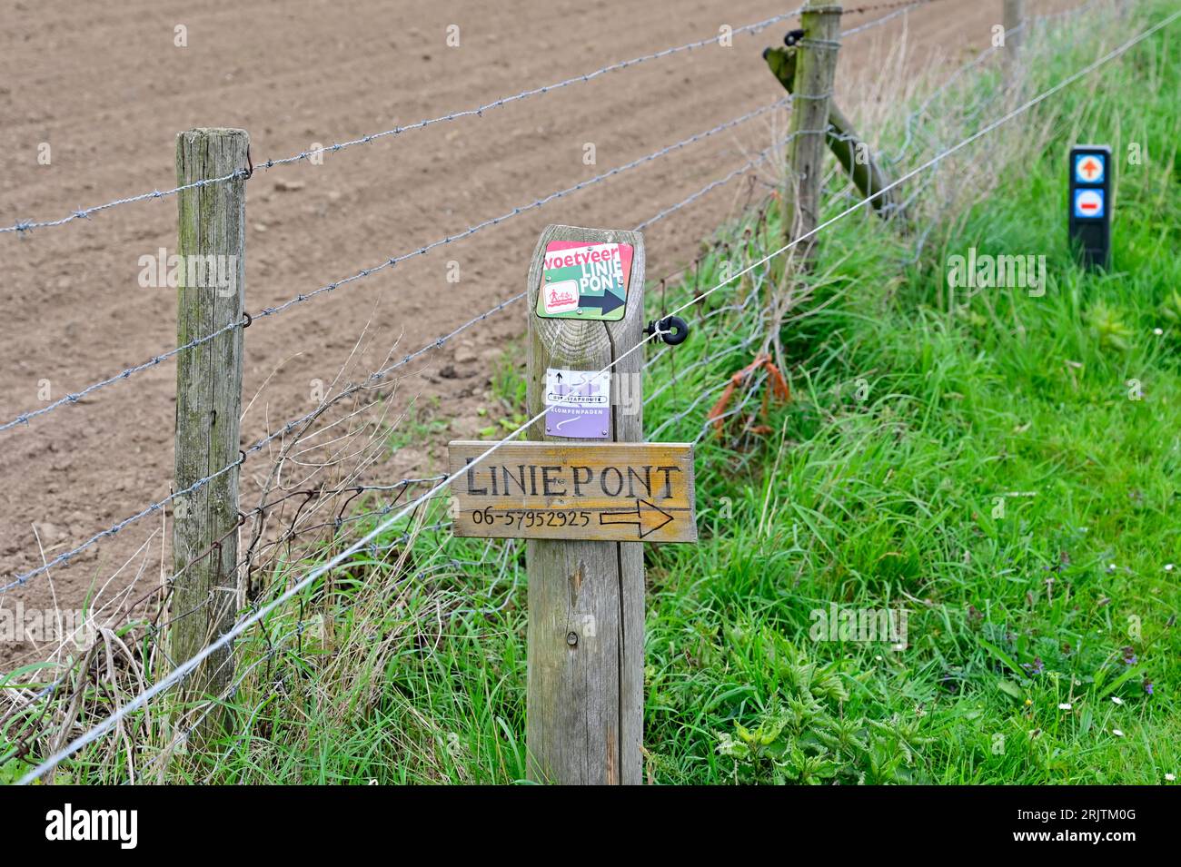 On a walking path outside the dike, a sign on a pole, also used as a ...
