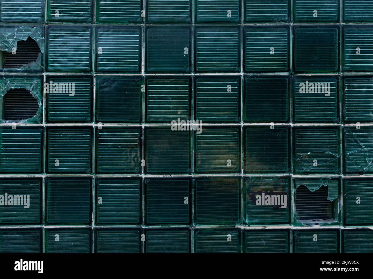 Damaged glass block window at an infrastructure facility. Dark ...
