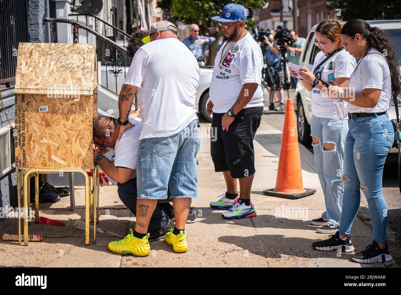 Eddie Irizarry, kneeling far left, is comforted by family members as he ...