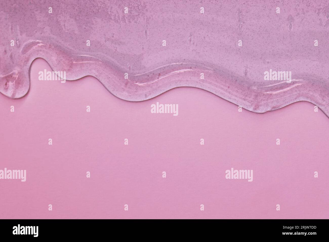 viscous pure transparent cosmetic gel on pink background. tactile , skincare, cosmetics concept ...