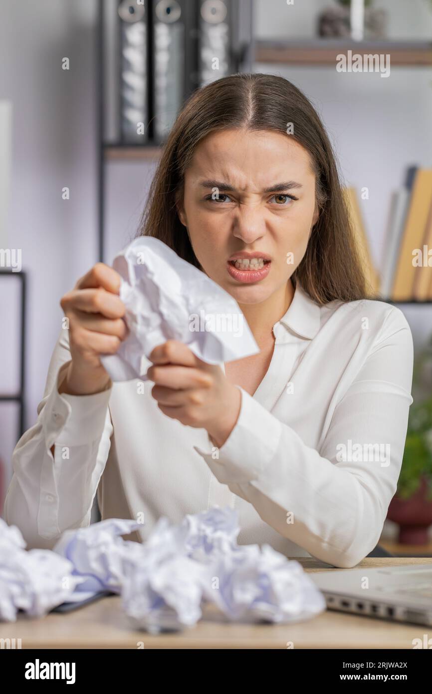 Angry furious business woman working at office throwing crumpled paper ...
