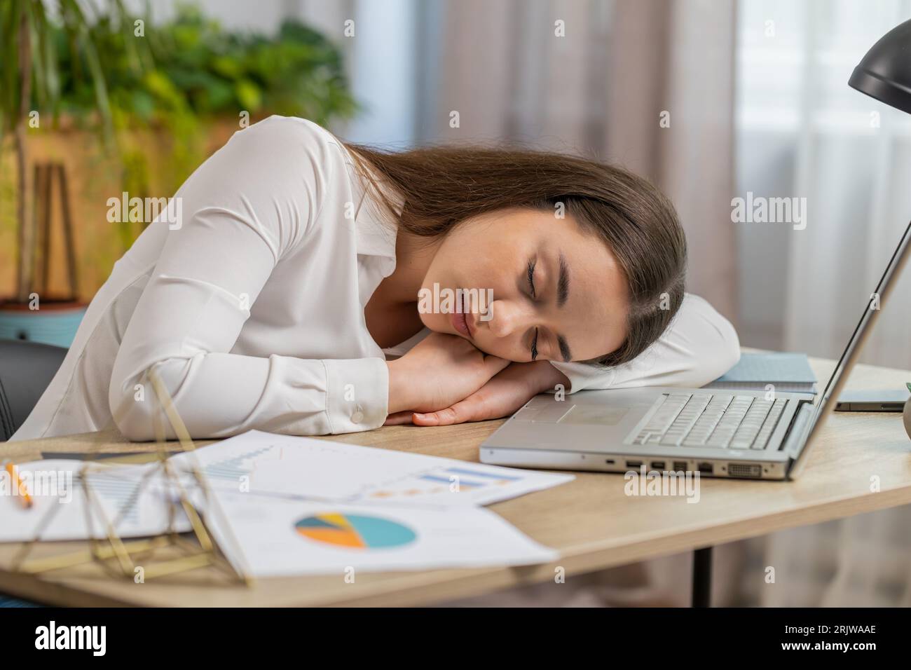 Bored sleepy Caucasian young business woman worker working on laptop ...