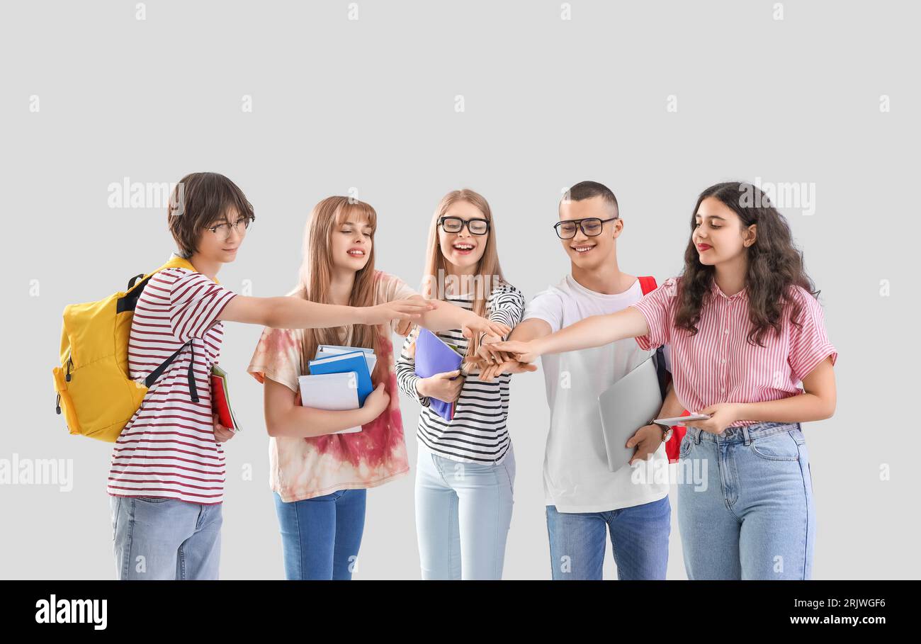 Group of students putting hands together on light background Stock ...
