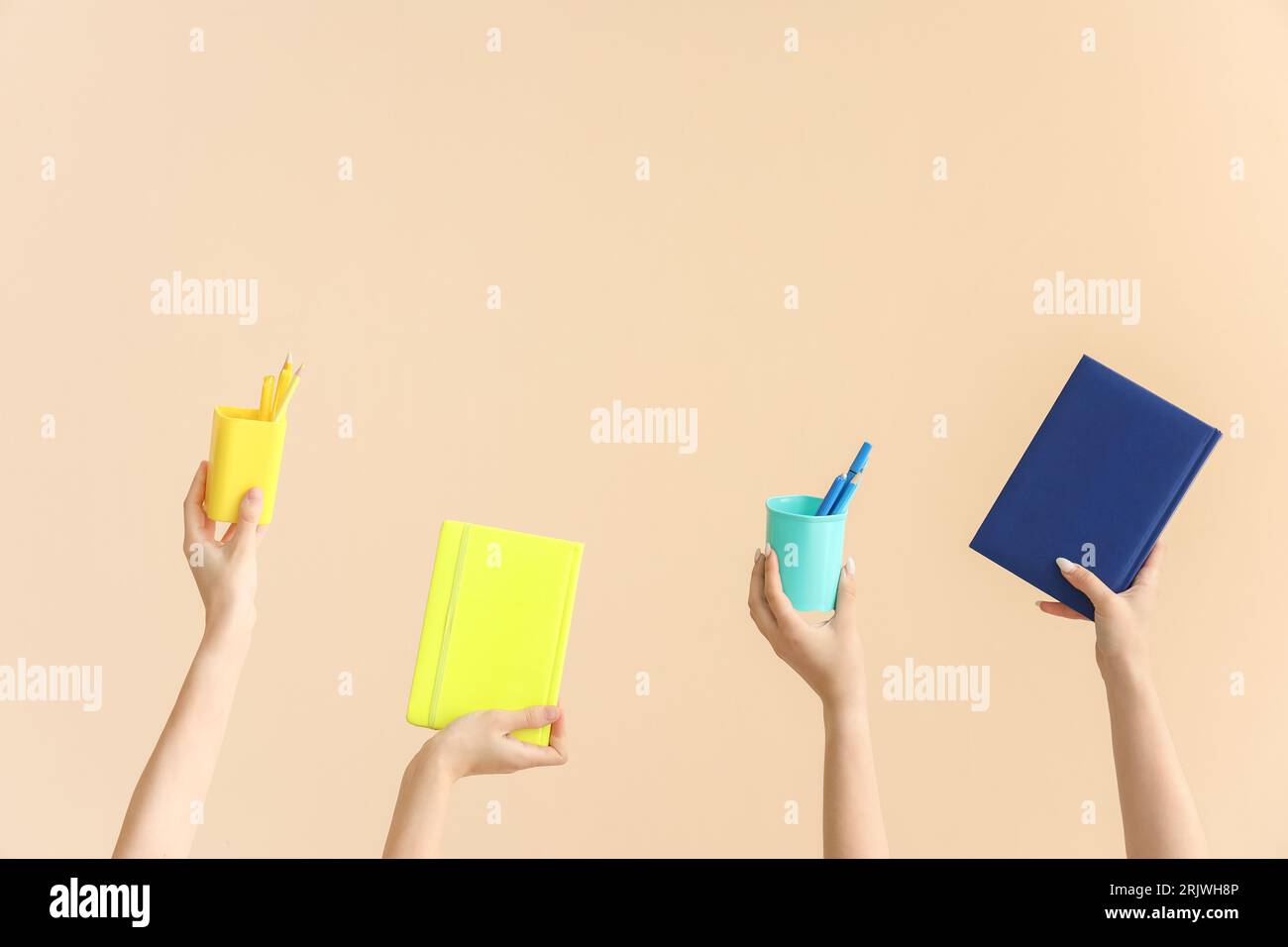 Hands holding school supplies on beige background Stock Photo - Alamy