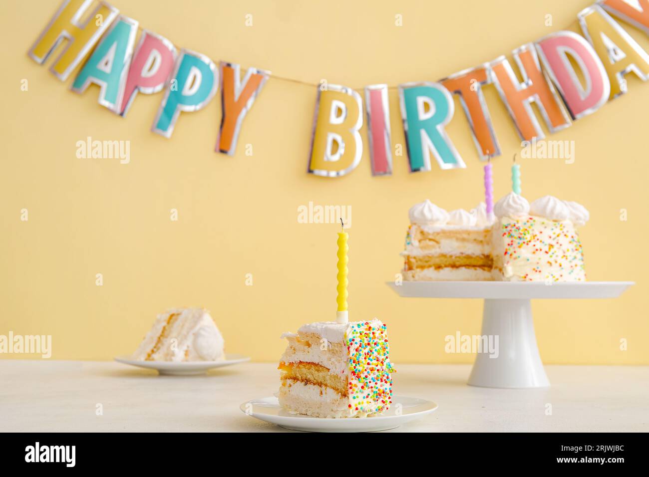 Party garland and stand with yummy Birthday cake on table near beige ...