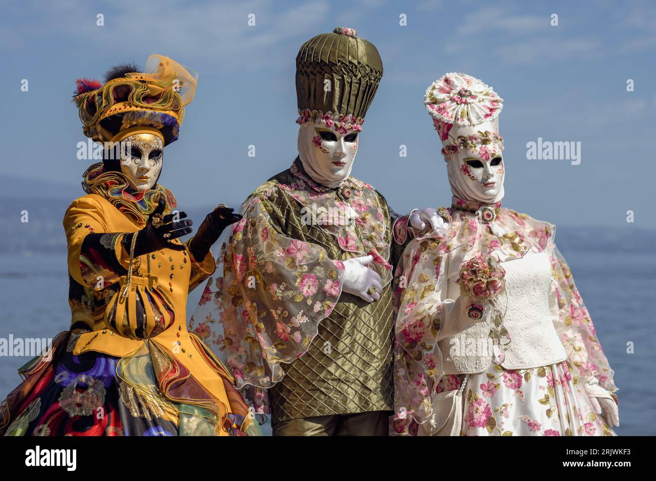 Venetian carnival. Three people wearing orange carnival costumes and ...