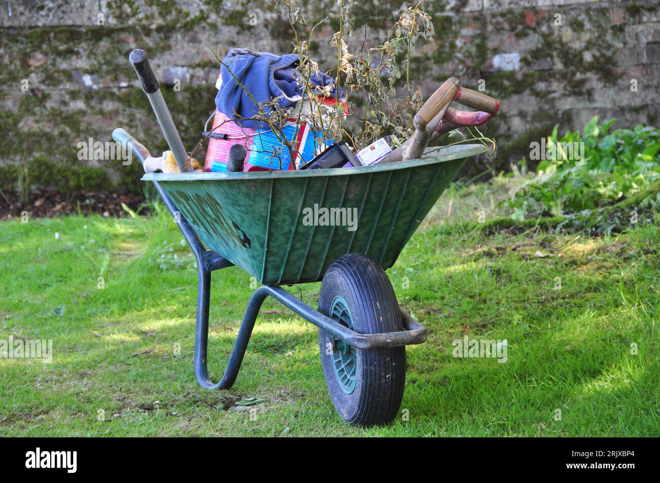 Garden wheelbarrow full of gardening tools and cuttings etc Stock Photo ...