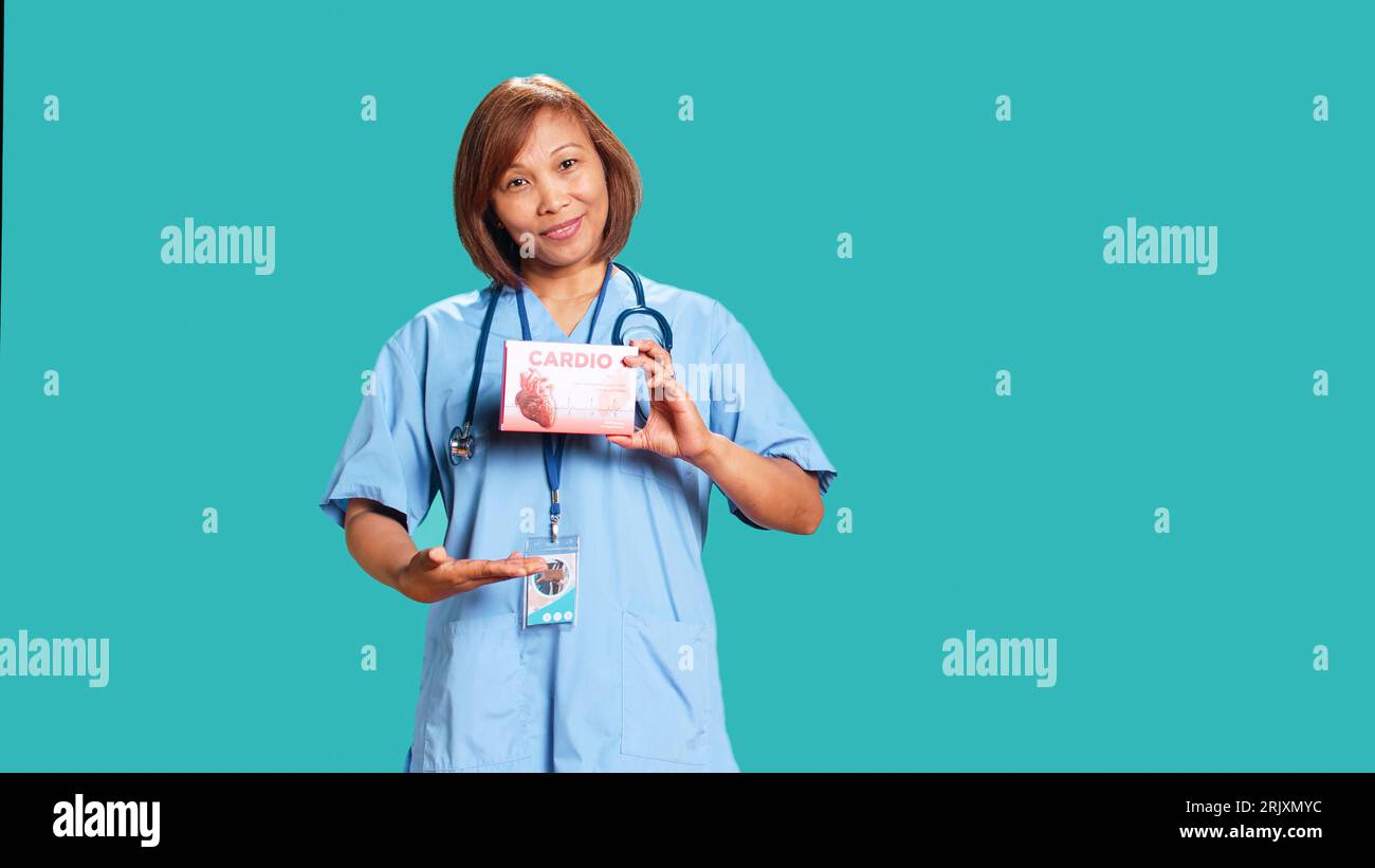Nurse holding cardiovascular tablets box, reading informations on ...