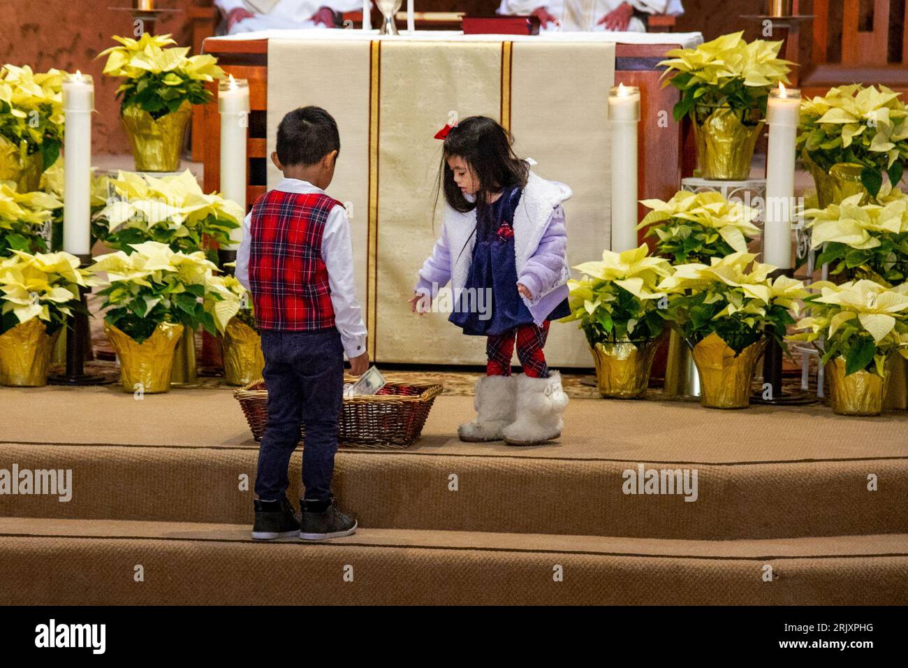 An Asian American brother and sister drop a money contribution in a ...