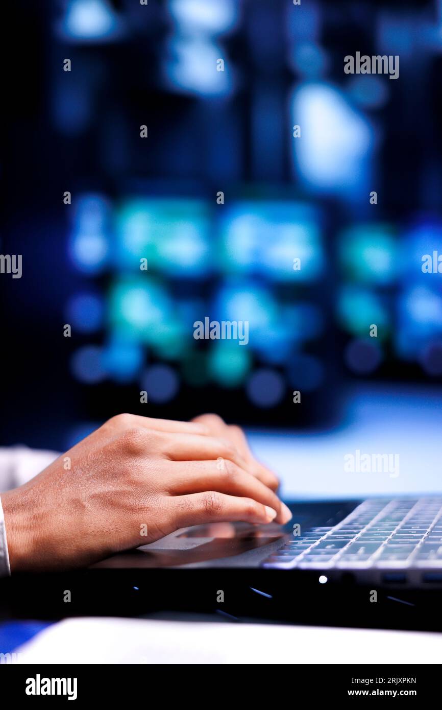 Close up shot of manager in server hub using laptop to set up ...