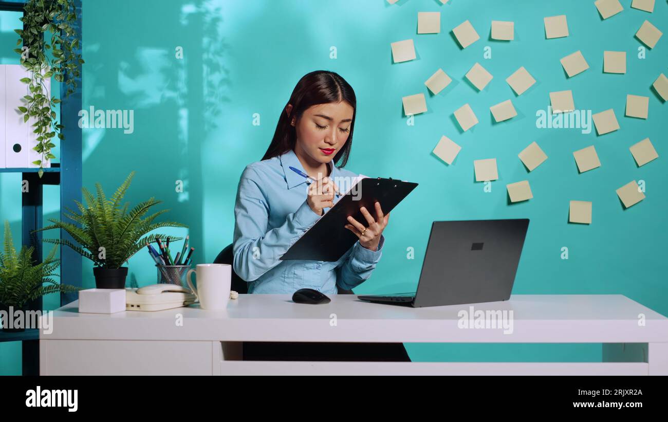 Determined hardworking asian employee cross-checking bureaucratic data ...