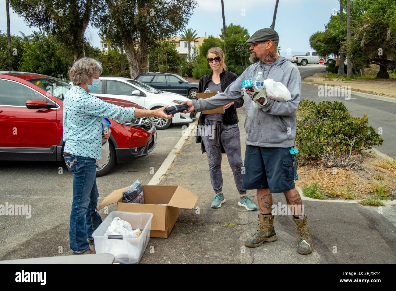 Sponsored by a local Catholic church, volunteers distribute food to the ...