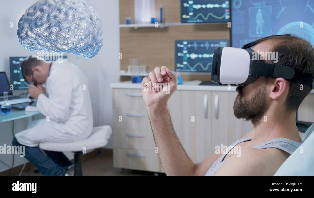 Experiment subject laying in lab bed wearing virtual reality headset ...