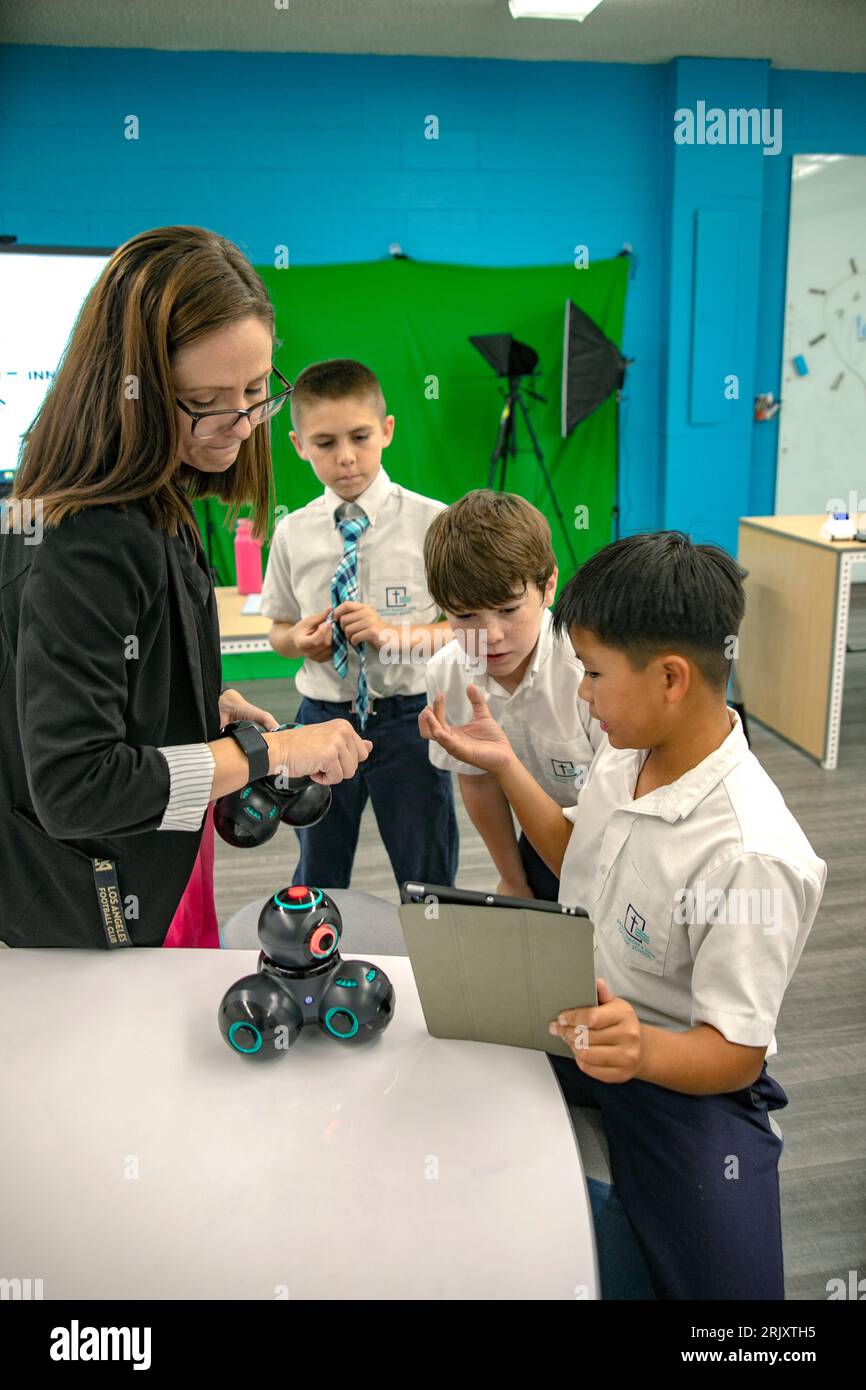 A teacher helps boys program a CUE robot at an innovation-oriented ...
