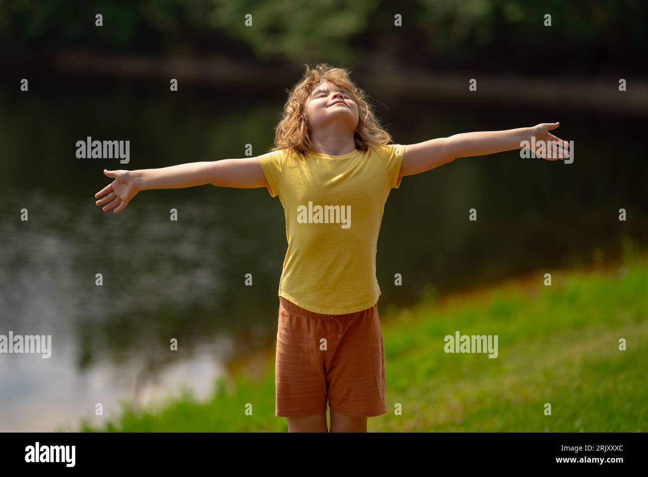 Happy child with arms up enjoying freedom in nature. Child with open ...