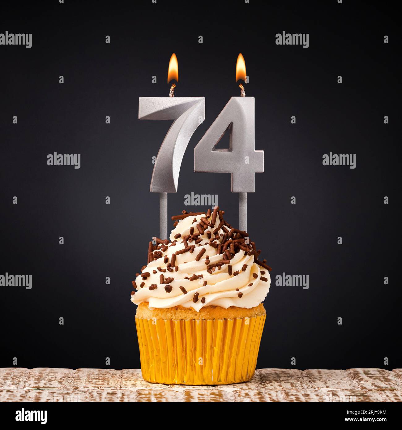 birthday cupcake with number 74 candle - Celebration on dark background ...