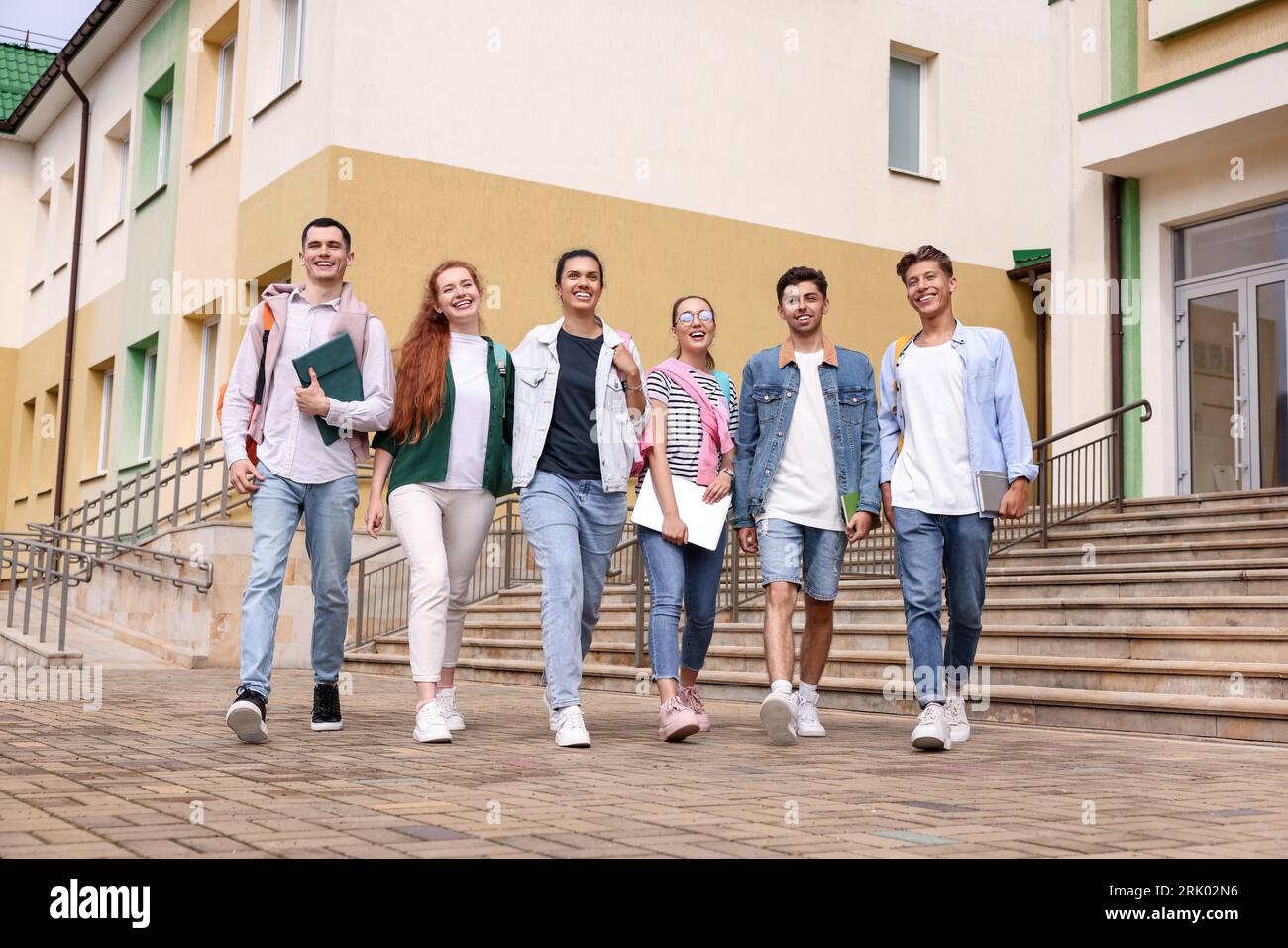 Group of happy young students walking together outdoors Stock Photo - Alamy