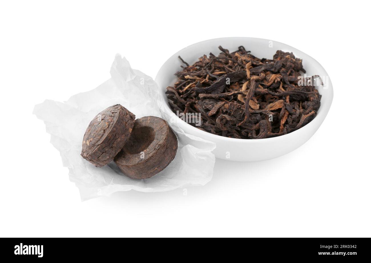 Cake shaped traditional Chinese pu-erh tea and leaves isolated on white ...