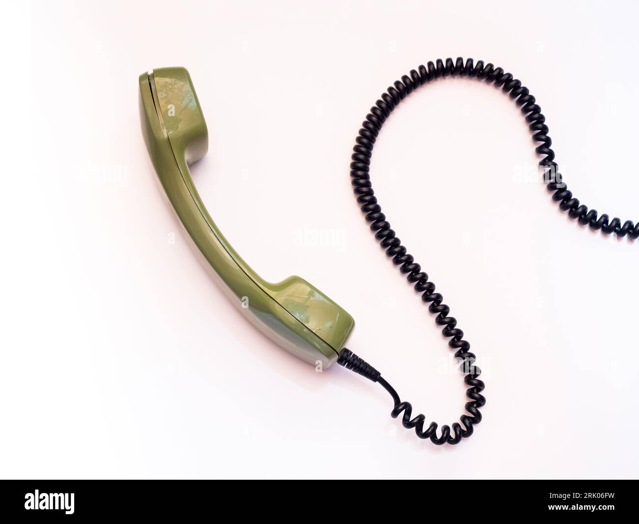 The handset of an old rotary phone lies on a white background. The ...