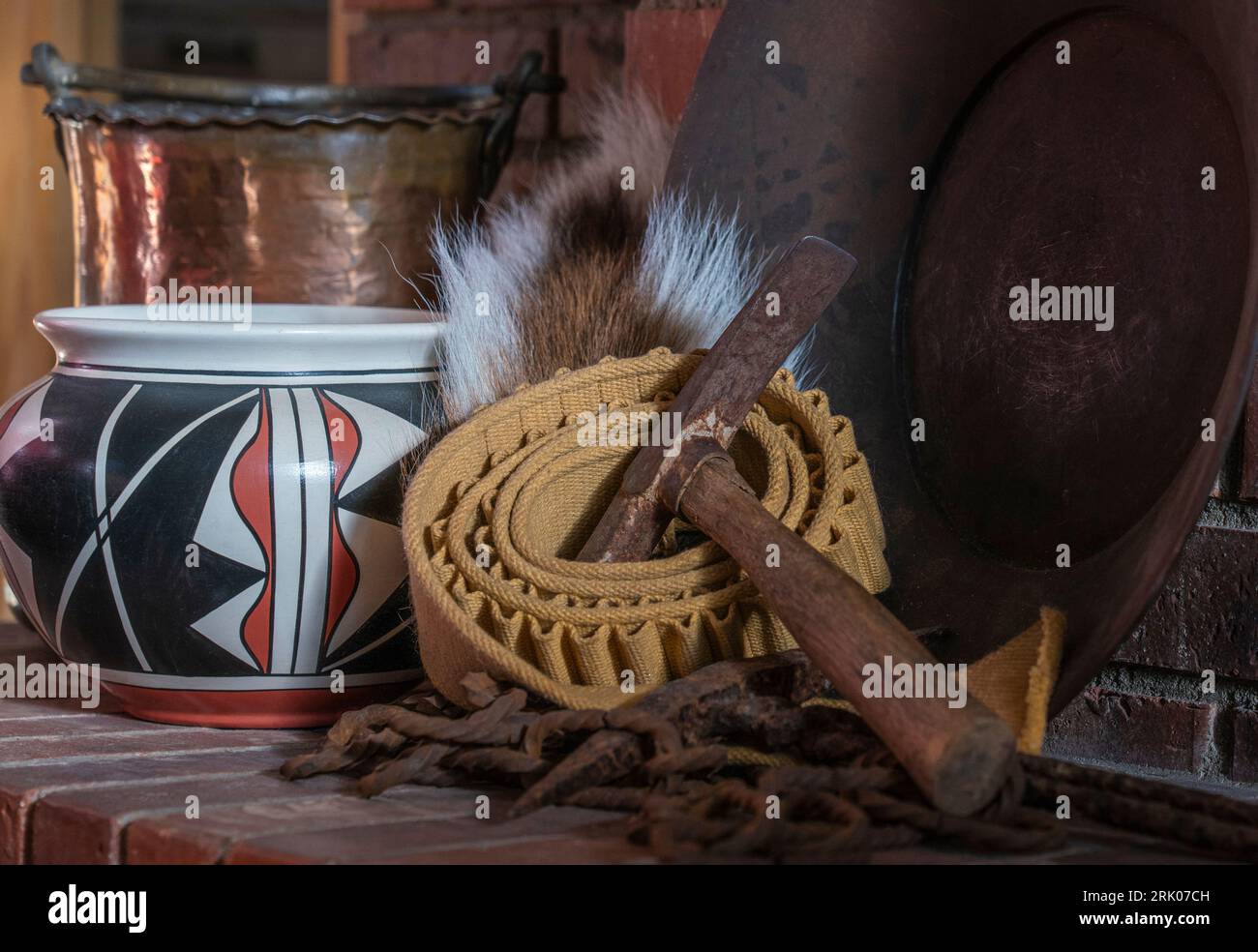 Hearth of red brick displays American Indian pottery, cartridge belt ...