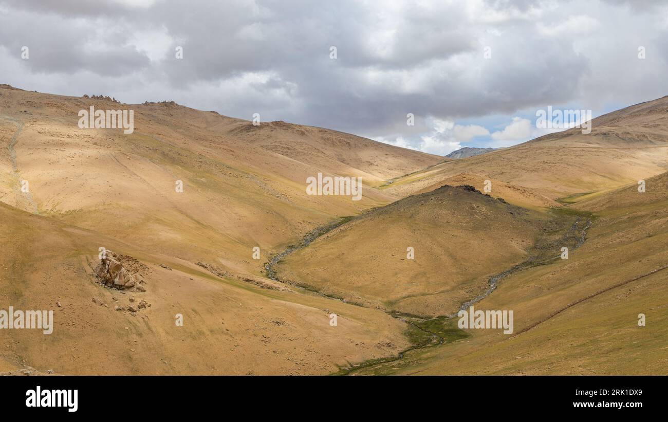 An open landscape at the higher reaches of Ladakh with brown pastures ...