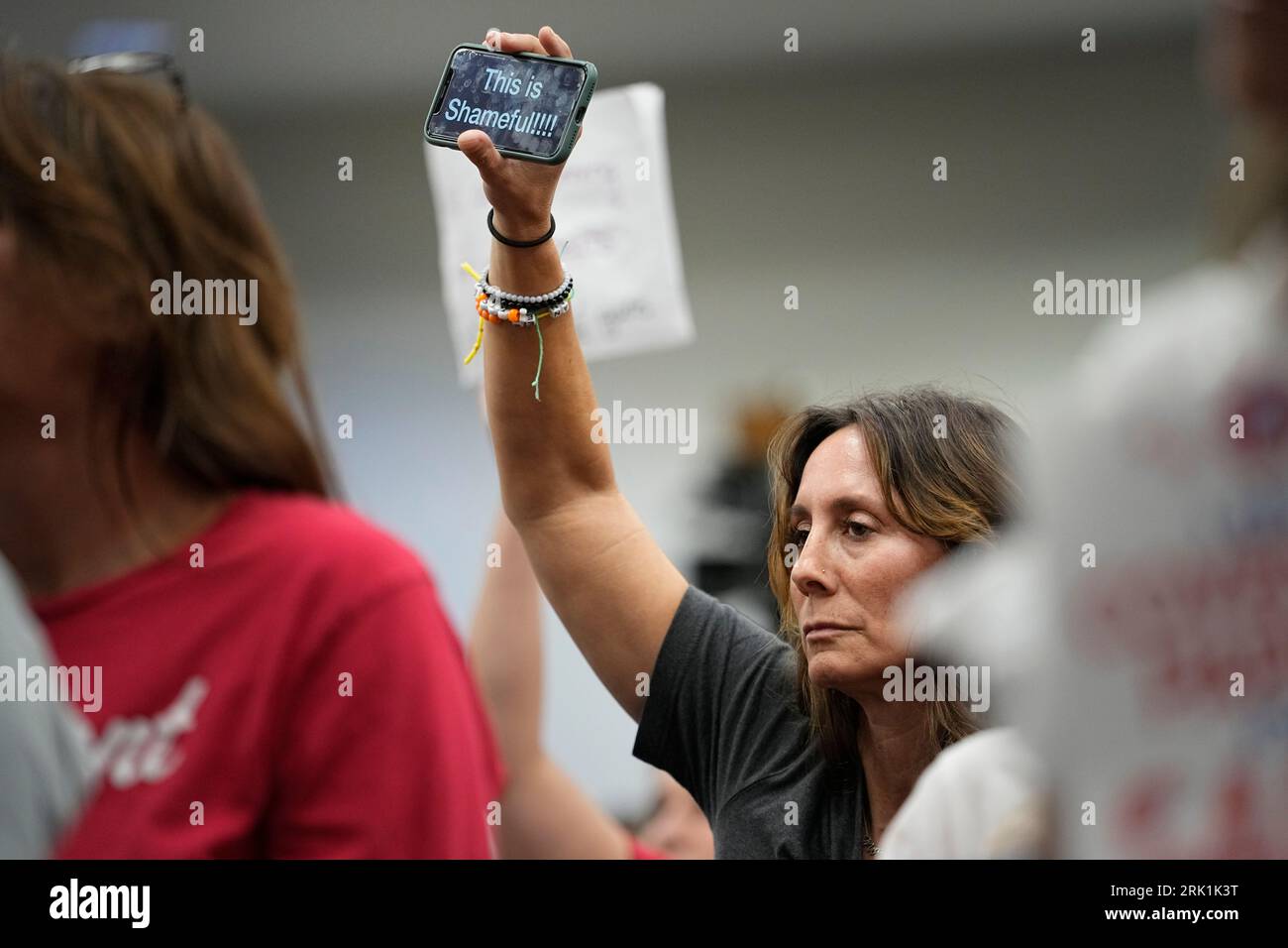 Ashley Warbington holds a sign as she sits in the audience of a House ...