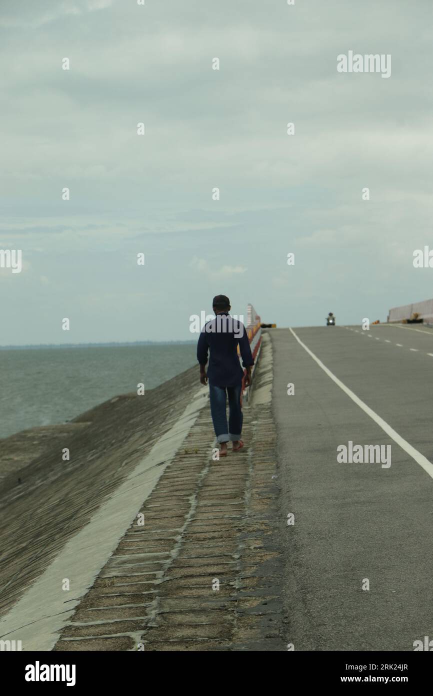 Man walking on the side of the street Stock Photo - Alamy