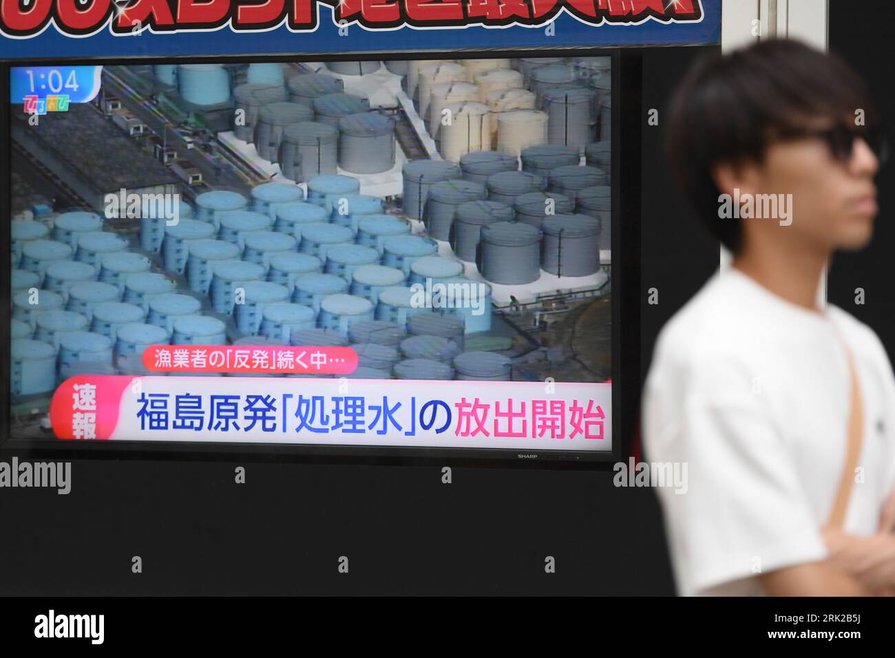 TV screen shows a news report on the release of the treated radioactive ...