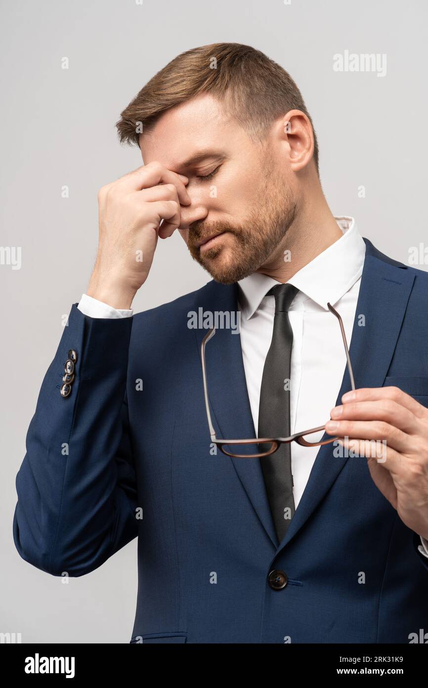Businessman takes off glasses, massaging eyelids of eyes. Overworked ...