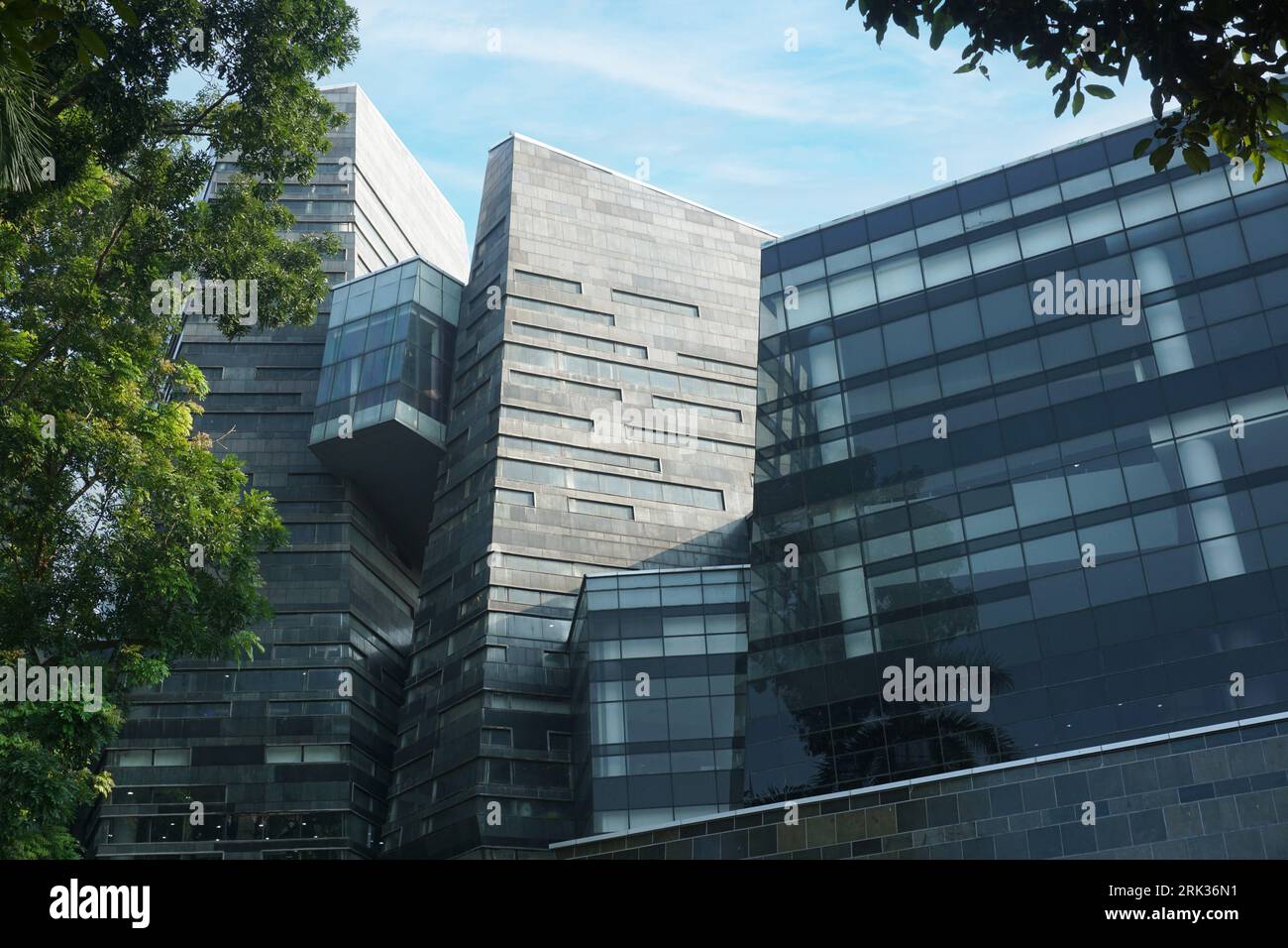 Modern eco-friendly glass architecture and greens against blue sky ...